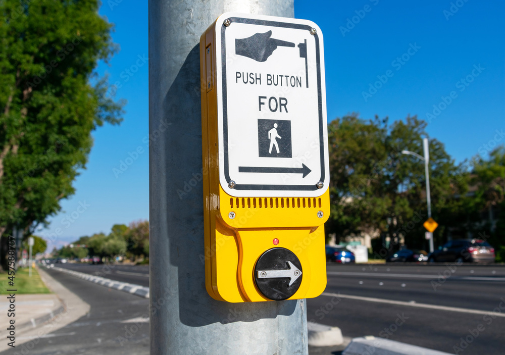 Pedestrian crosswalk call button installed at traffic lights with a ...