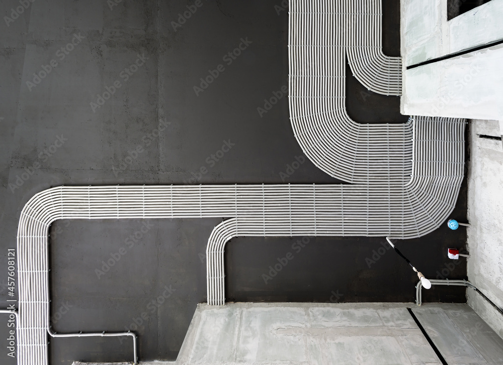 Electrical cables and pipes on house concrete ceiling background ...
