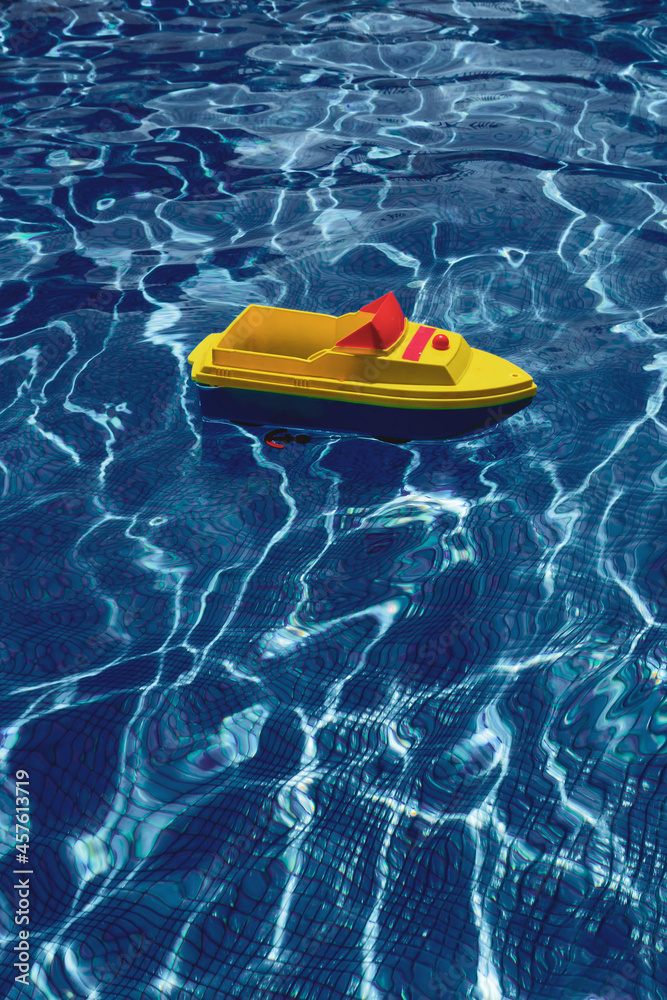 Yellow toy boat in swimming pool Stock Photo | Adobe Stock