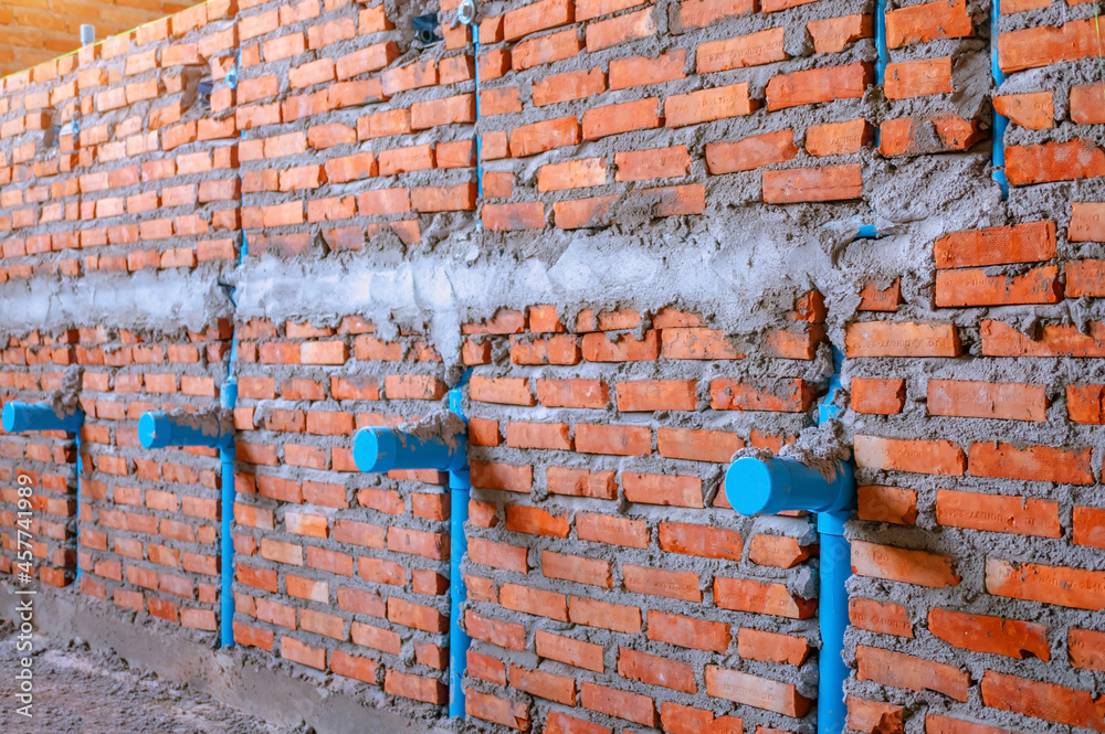 Water supply pipe layout work. Chrome pipes and fittings on brick wall ...