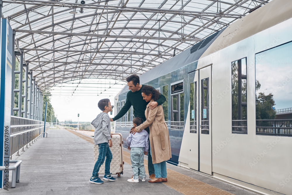 Full length of happy family with two little kids bonding while standing ...