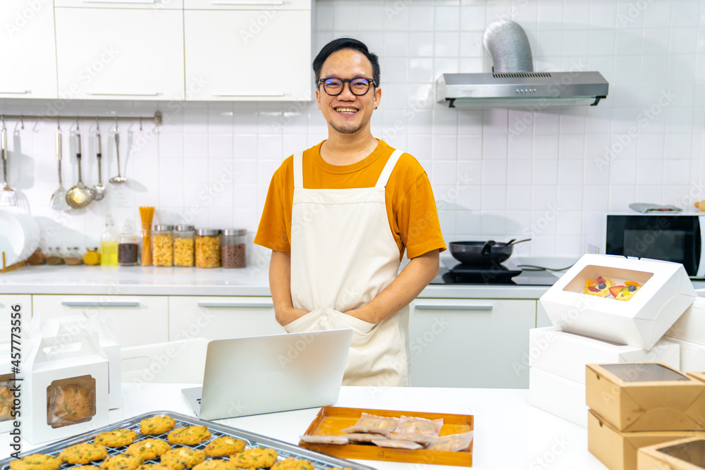 Portrait of Asian man bakery shop owner using laptop computer ...