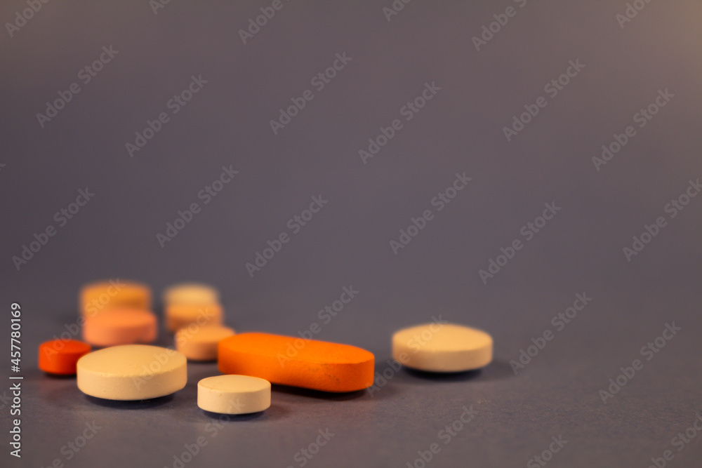 numerous colored pills on neutral background. Medicines for use in ...