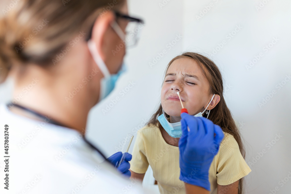 Nurse performing a nose swab test on a little child. Girl going through ...