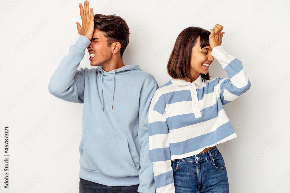 Young mixed race couple isolated on white background forgetting ...