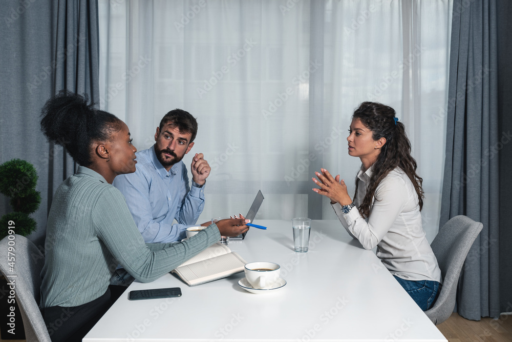 Foto de Three young experts business people having a meeting and ...
