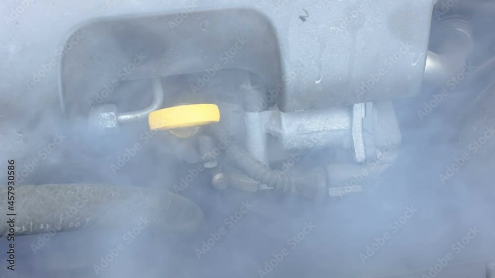 Closer look of the busted engine of the car with the white smoke coming ...