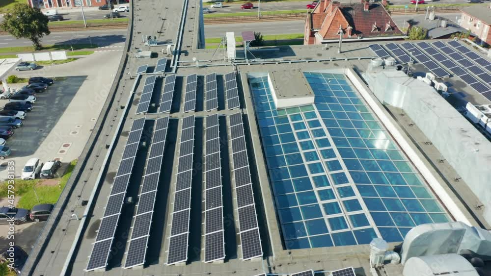 Drone shot at a new solar farm installed on the flat roof of an office ...