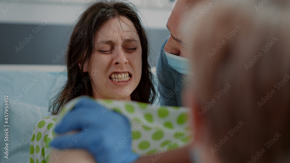 Close up of pregnant woman pushing and screaming in hospital ward at ...