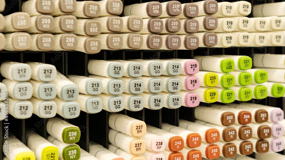 Sketching markers are arranged in cells on the shelf of a stationery ...