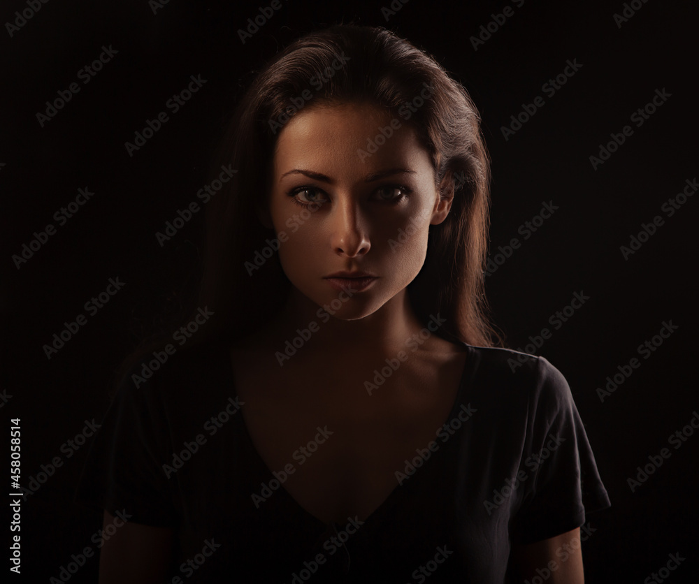 Beautiful serious mysterious woman in darkness looking dramatic ...