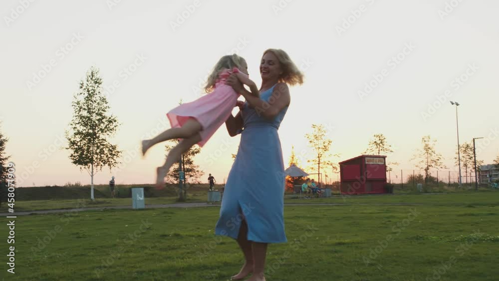 Vídeo do Stock: The mother twists her little daughter in a circle, then ...