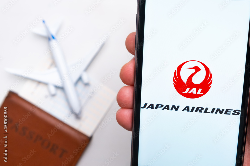 Japan airline company logo on the screen of mobile phone in man hand on ...
