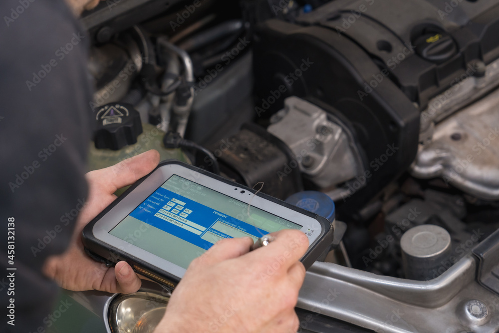 Car repair workshop, checking the interior of the engine with a ...