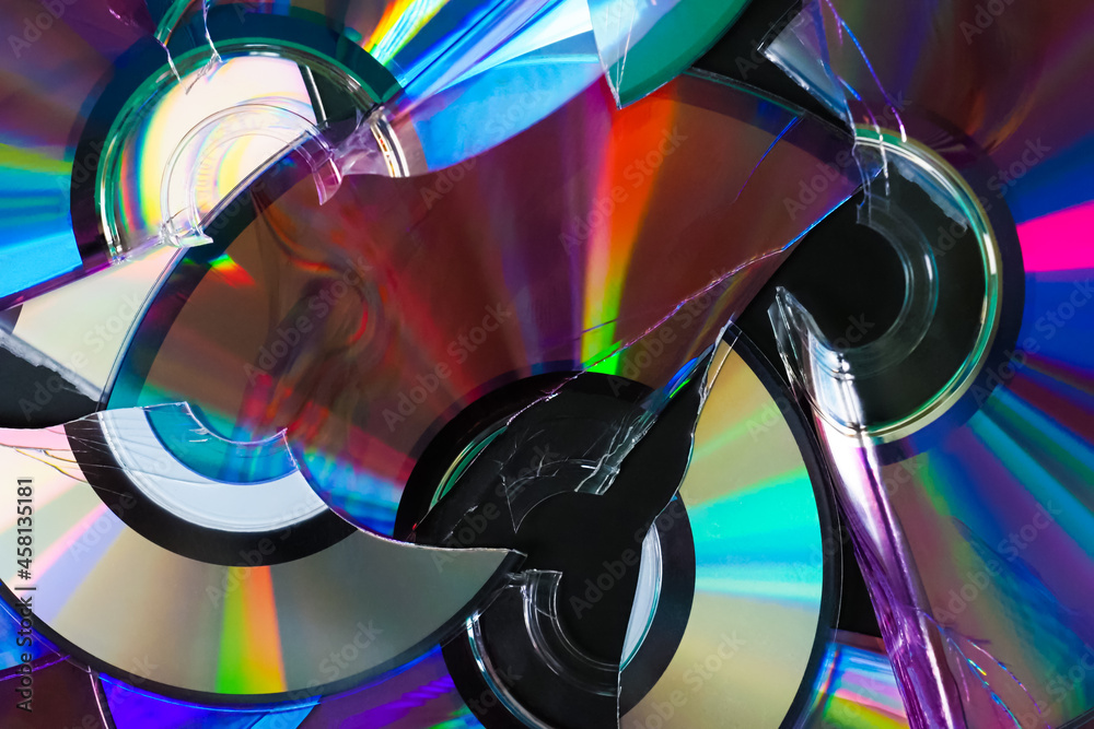 Stack of broken CD and DVD discs. Data destruction background. Damaged ...