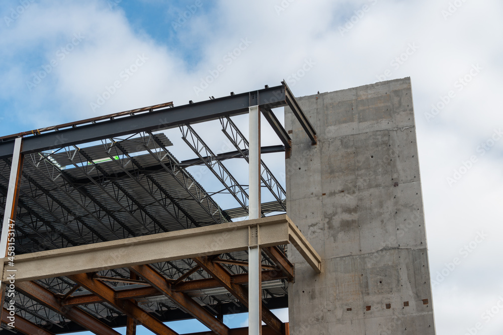 A large multiple storey metal building wall with steel beams against a ...
