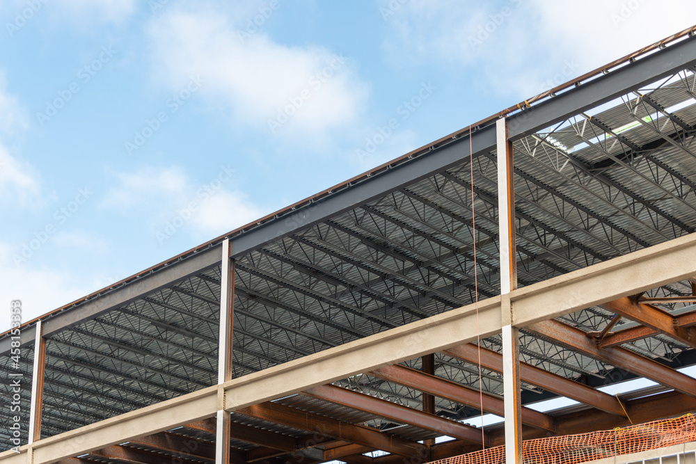 A large multiple storey metal building wall with steel beams against a ...