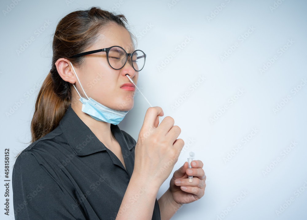 Foto de Young Asian woman using rapid antigen test kit by nasal swab ...