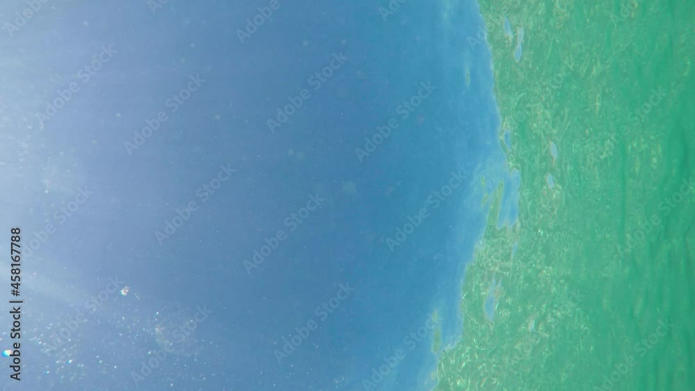 Tranquil underwater shot at the beach, sun rays and floating sand (4k ...