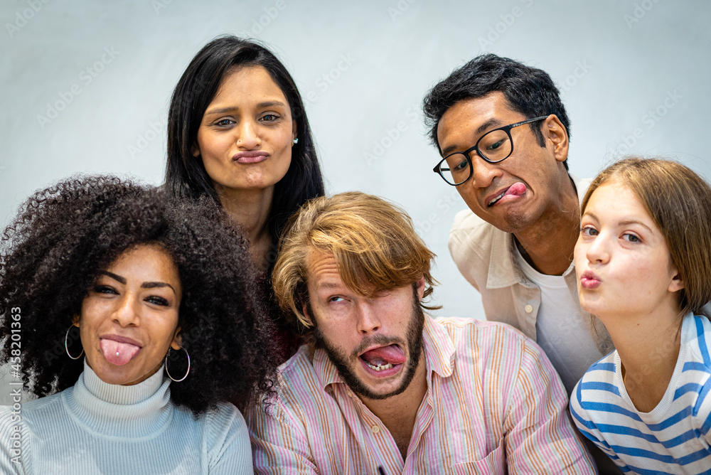 cheerful multiracial friends making a selfie sticking out tongue and ...