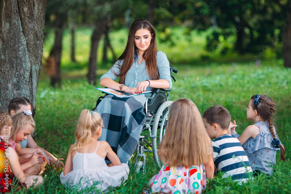 Disabled teacher conducts a lesson with children in nature. Interaction ...