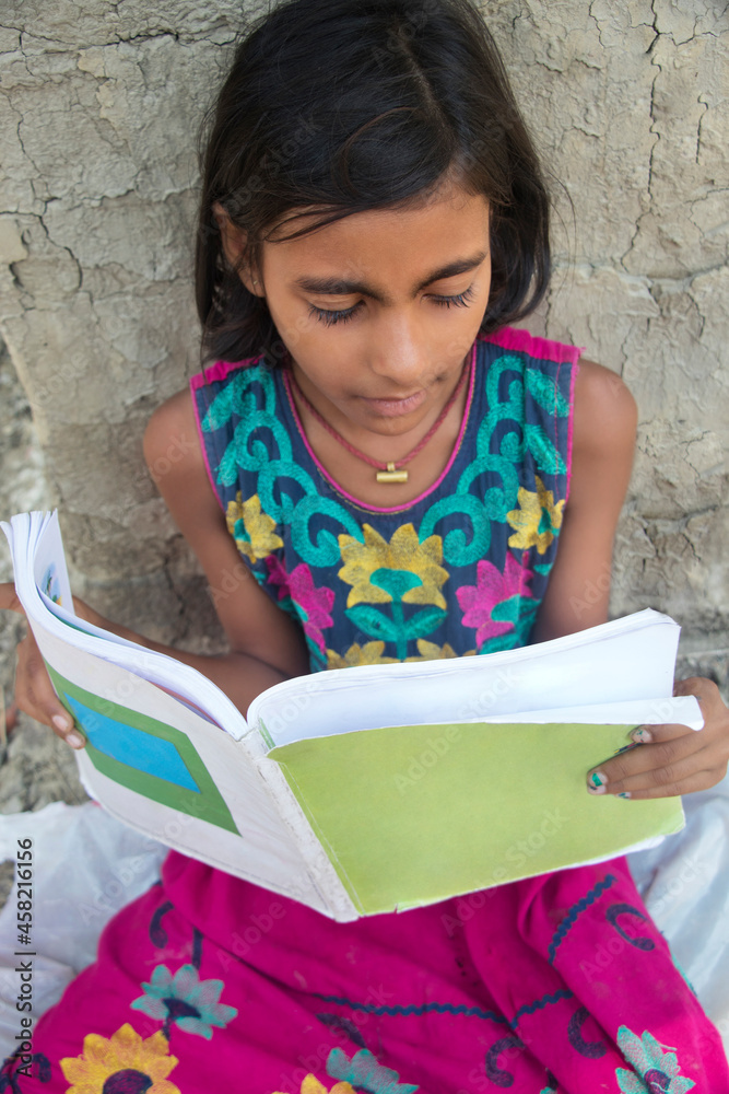 Indian rural girl reading book at home Stock Photo | Adobe Stock