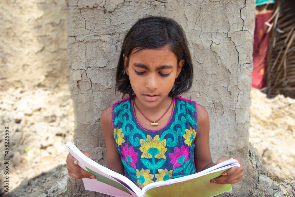 Indian rural girl reading book at home Stock Photo | Adobe Stock