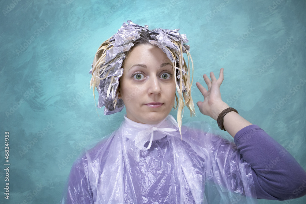 Funny woman portrait with bleached hair in foil and surprised face ...
