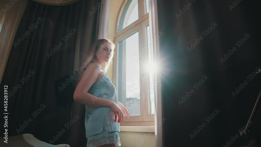 Vidéo Stock Elegant young woman in lingerie pulling curtains opening ...