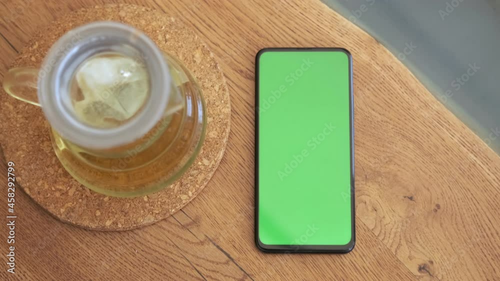 Smartphone place on table wood with green screen, Close-up the cell ...