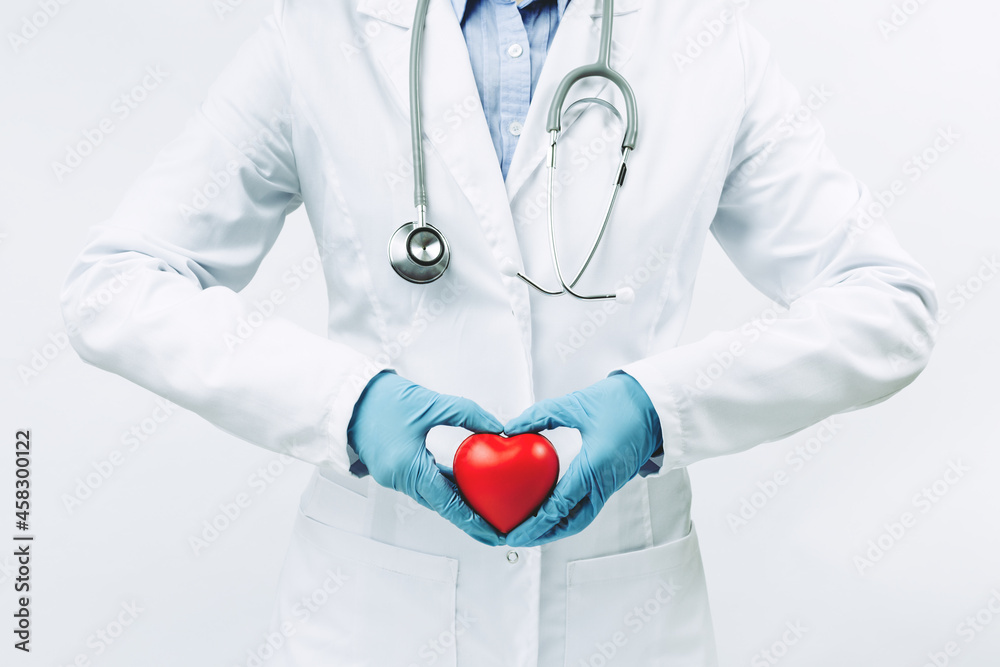 Female doctor in white uniform forms a heart shape with her hands ...