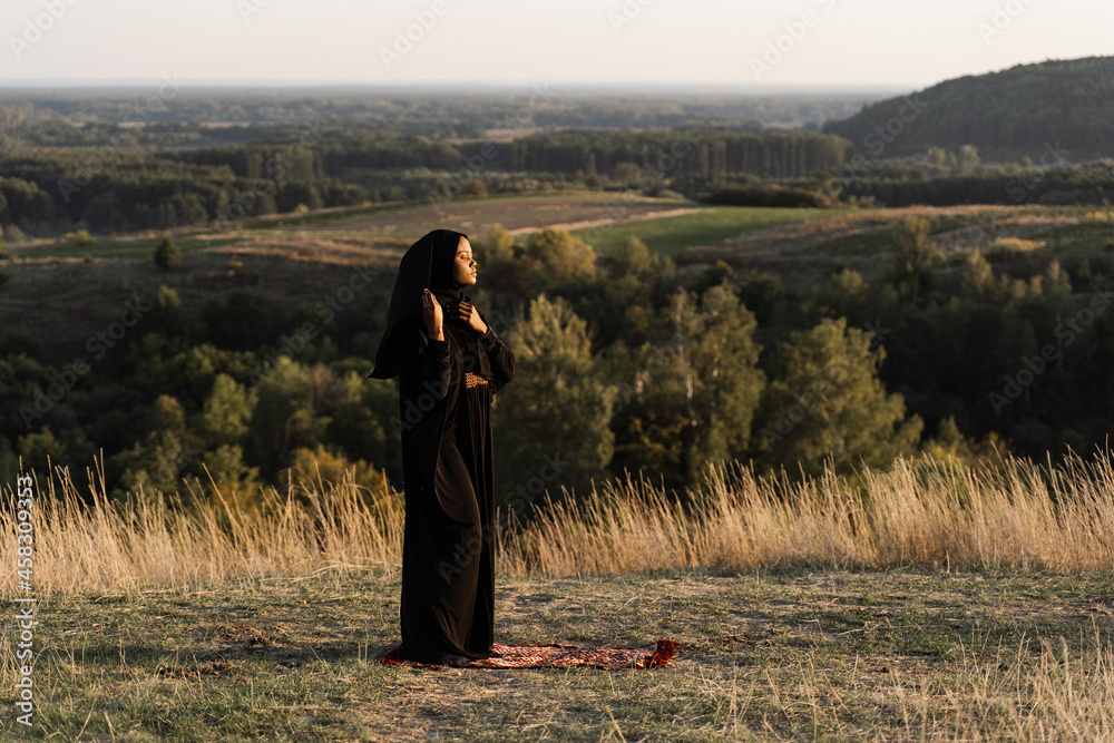 Black muslim woman praying on the carpet. Solat praying on the ...