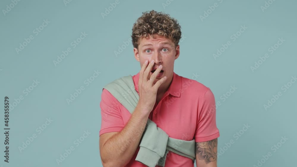 Scared shocked afraid young curly man 20s years old wears pink t-shirt ...
