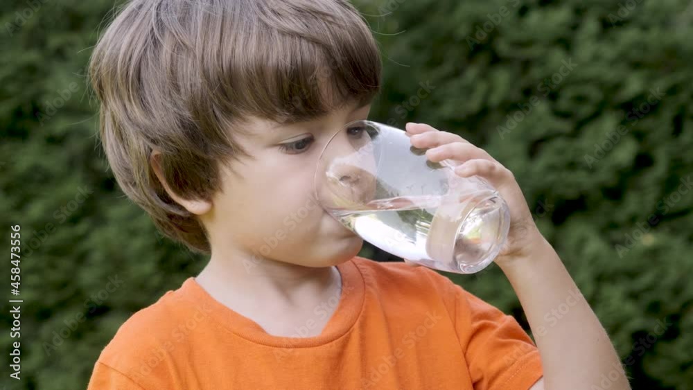 Thirsty Child Drinking Water From Glass Outdoors With Sun Shining. Kid ...