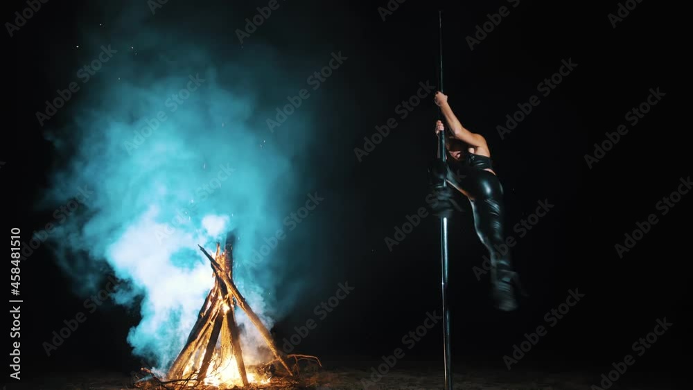 pole dance. witch halloween. fit female gymnast, in black leather ...