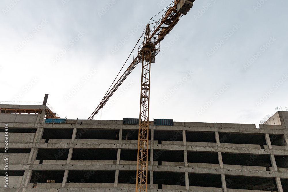 Construction crane over a building under construction. The concept of ...