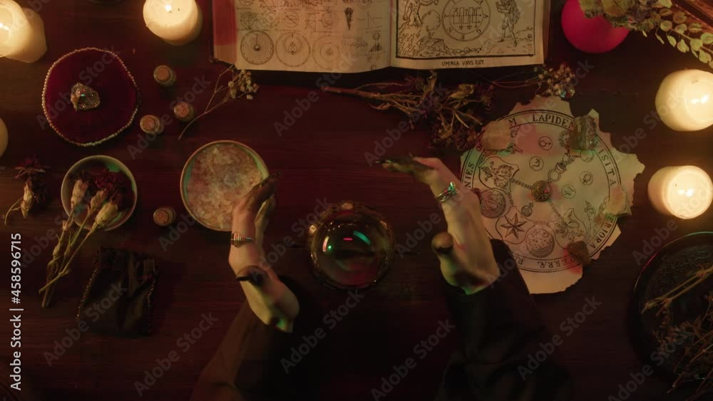 Witch using magic crystal ball top view. Table with spellbook for ...