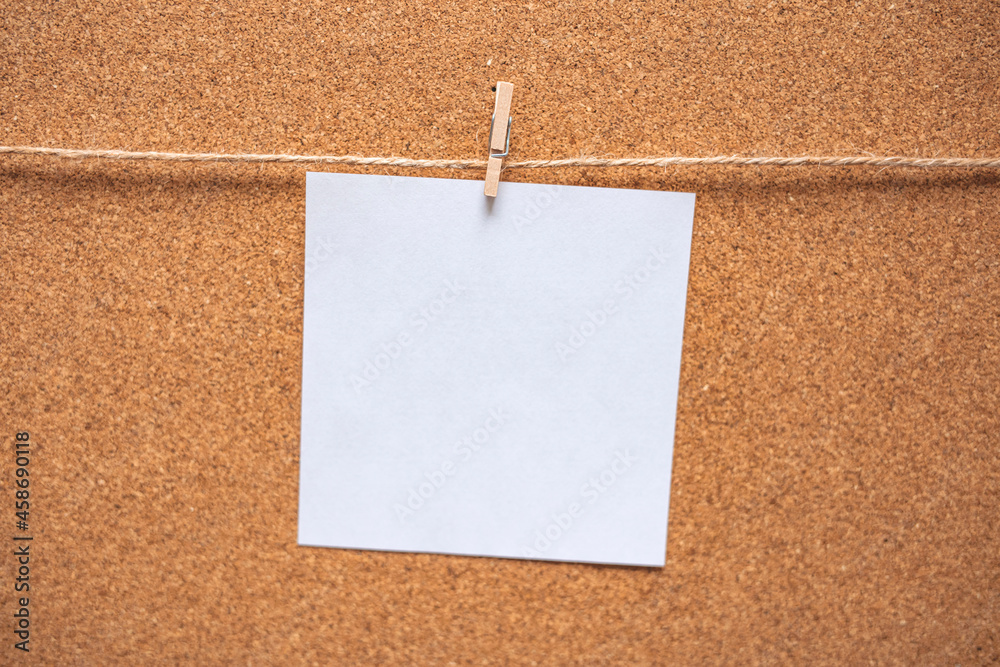 Empty post-it note pinned to corkboard background. Cork board with ...