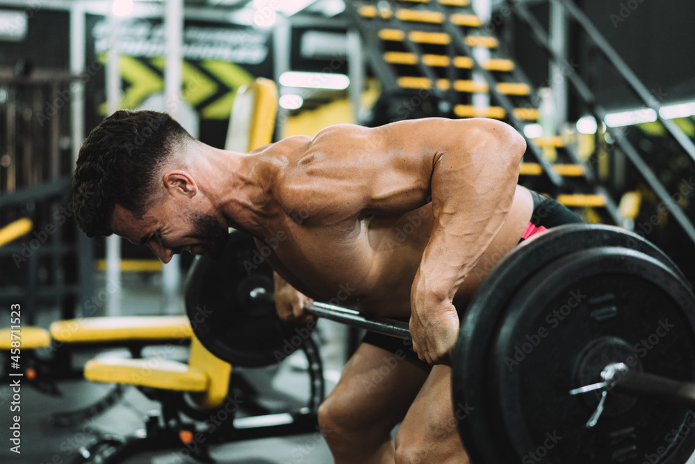 Profile of strongman lifting weights with the barbell in a gym Stock ...