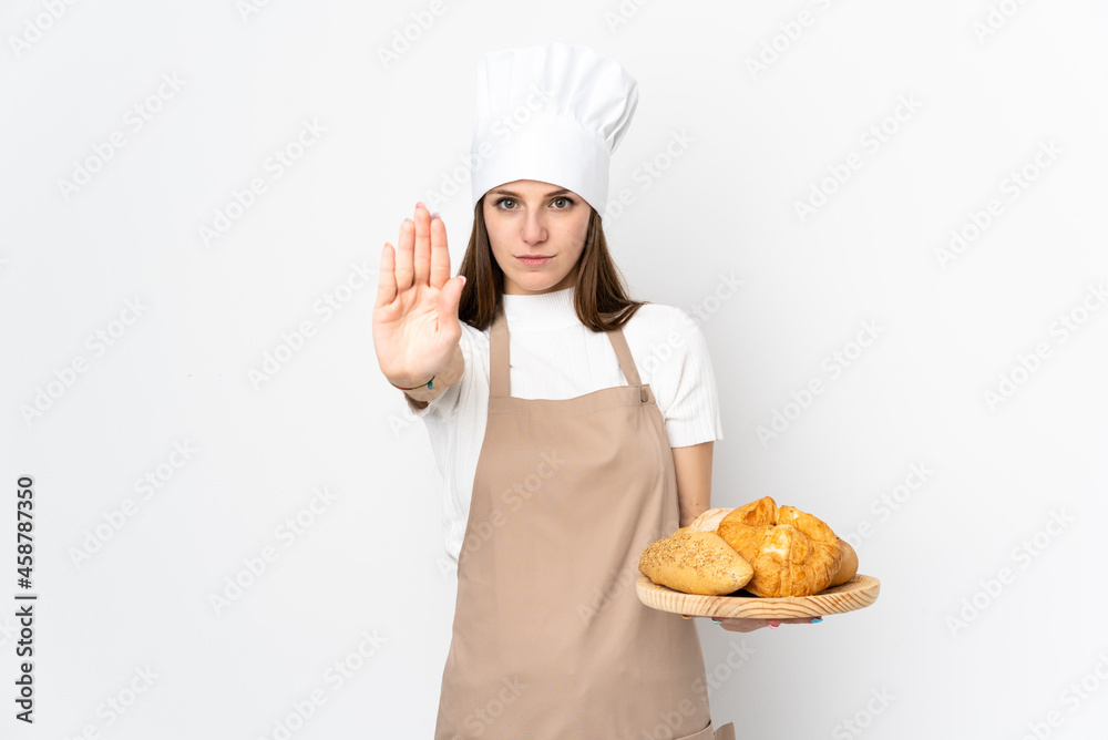 Young woman in chef uniform isolated on white background making stop ...