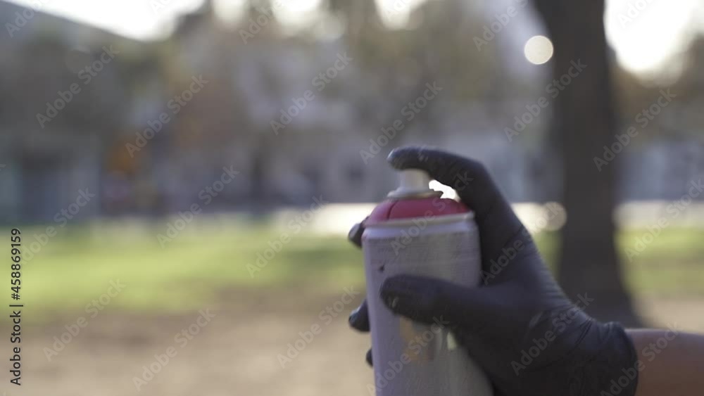 Slow motion shot of person spraying red spray paint into air ...