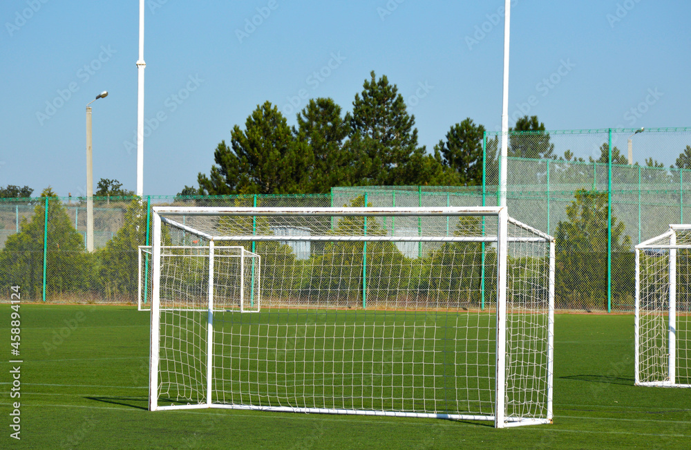 Foto de an empty football goal with a stretched net in a green stadium ...