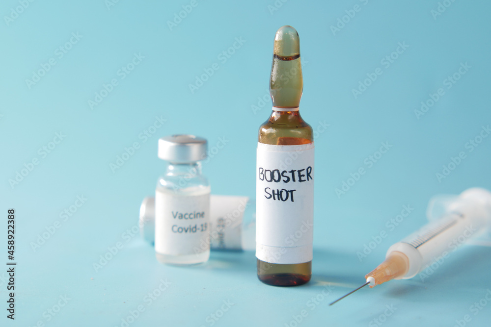 booster shot dose coronavirus vaccine and syringe on blue Stock Photo ...