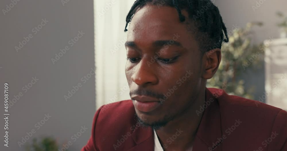 Vidéo Stock Handsome dark-skinned guy leans against desk with hands ...