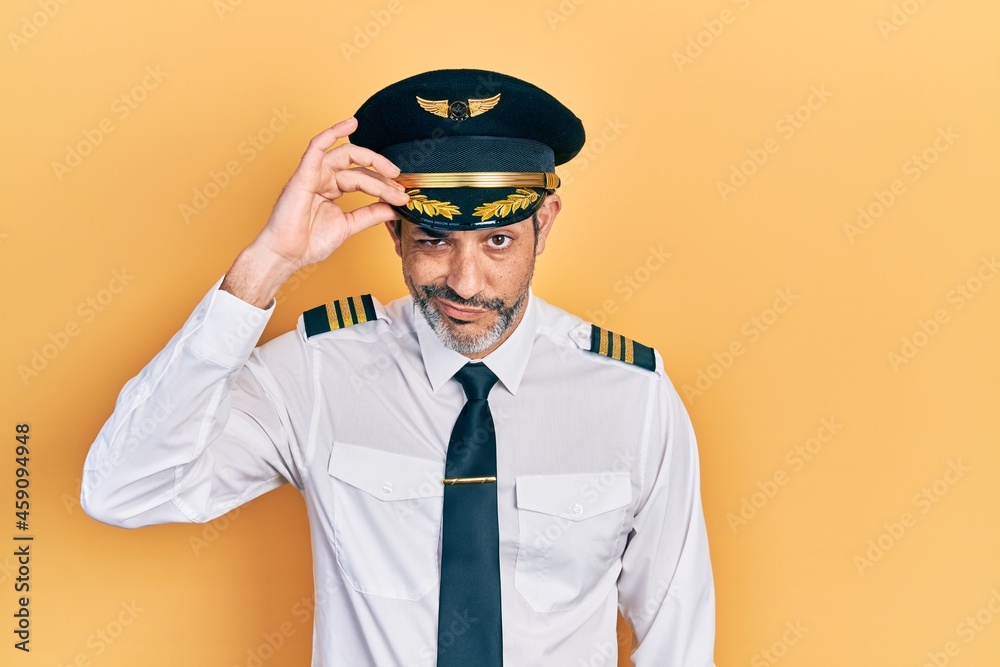 Handsome middle age man with grey hair wearing airplane pilot uniform ...