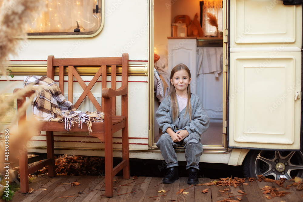 Smiling little girl in casual clothes sitting on porch RV house in ...