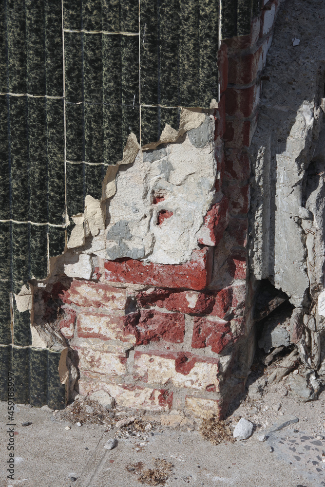 Full frame close-up view of a section of a brick building wall damaged ...