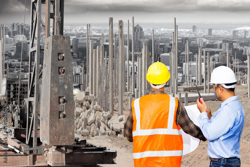 Civil engineer and foreman control working at pile driver works to set ...