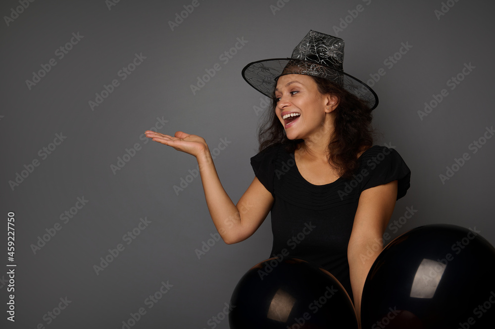 Joyful mixed race pretty woman dressed in witch carnival costume and ...