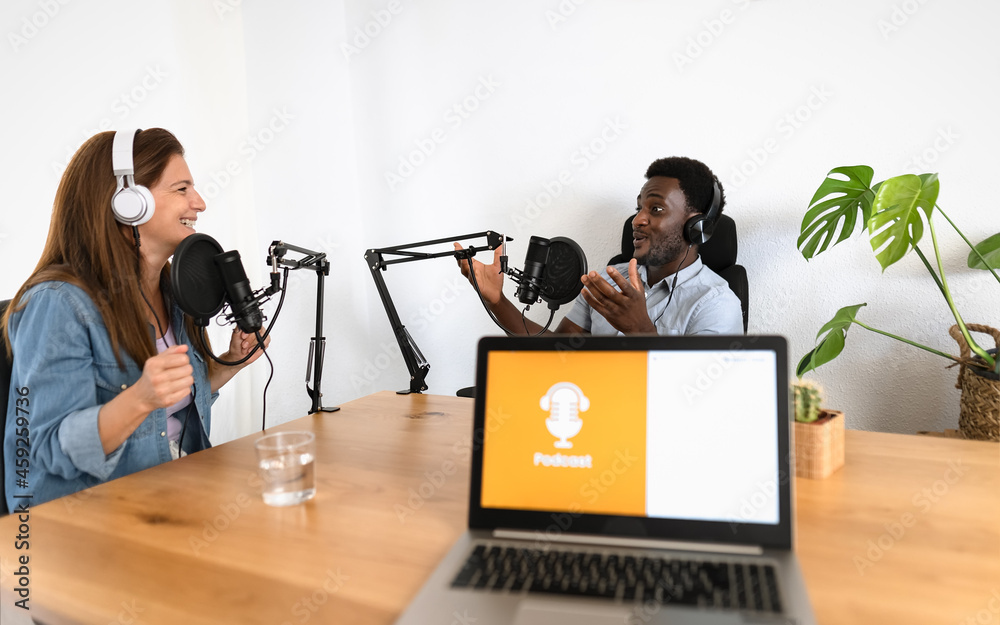 Multiracial people recording a podcast using microphone and laptop from ...